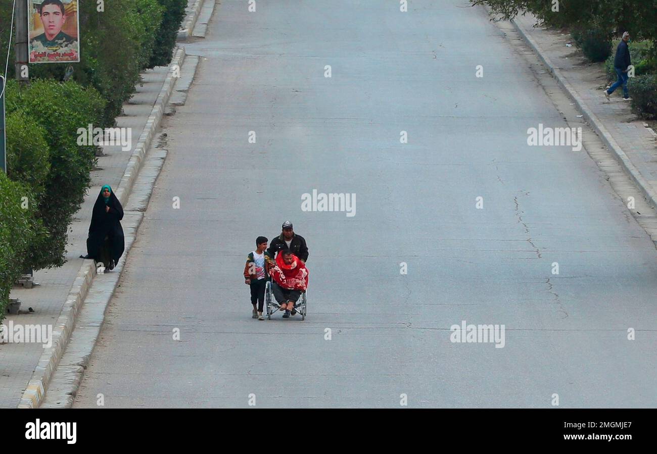 Iraqis walk in an empty street in central Baghdad, Iraq, Sunday, March ...