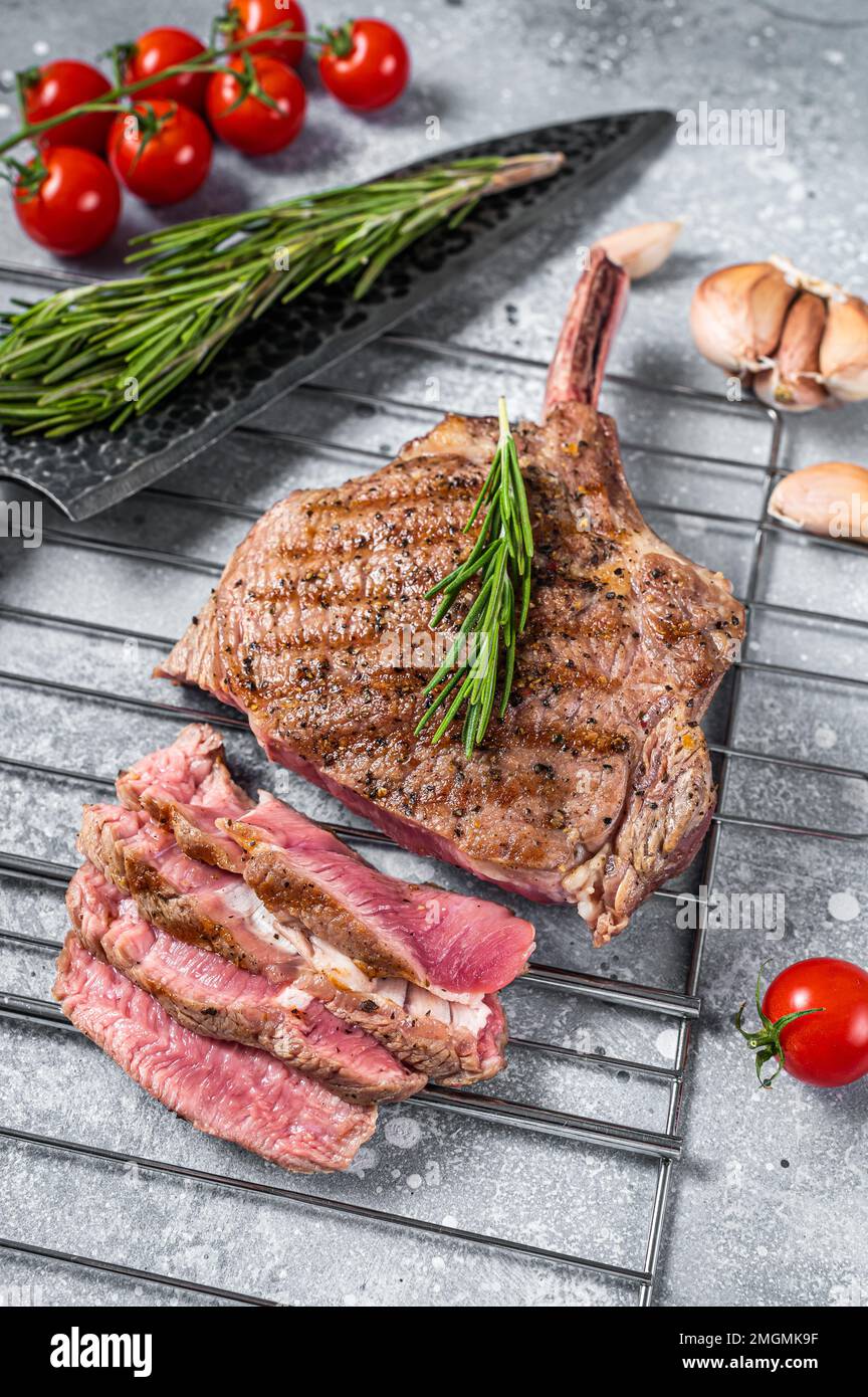 BBQ roasted sliced rib eye Tomahawk beef steak on grill. Gray ...