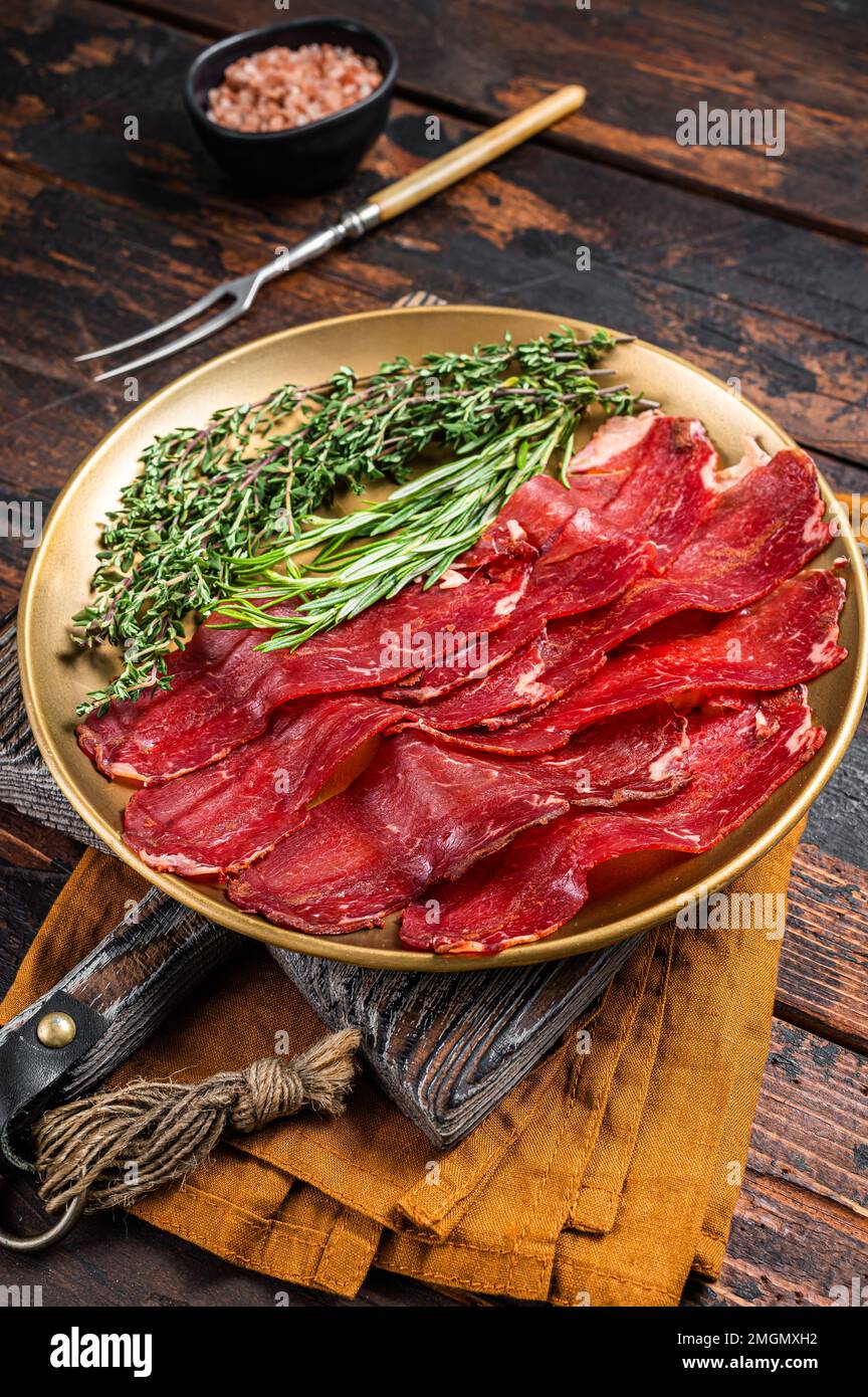 Basturma, sliced dried beef meat, meat Jerky in steel plate with herbs ...