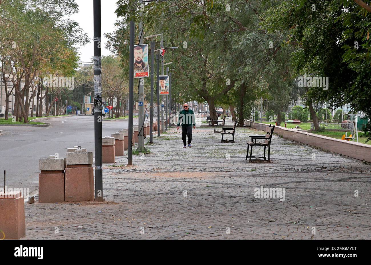 A man walks on a nearly empty Abu Nawas Street, in central Baghdad ...