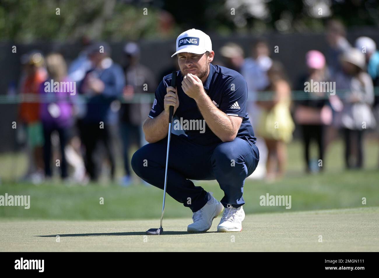 Tyrrell Hatton, of England, lines up his putt on the first green during ...