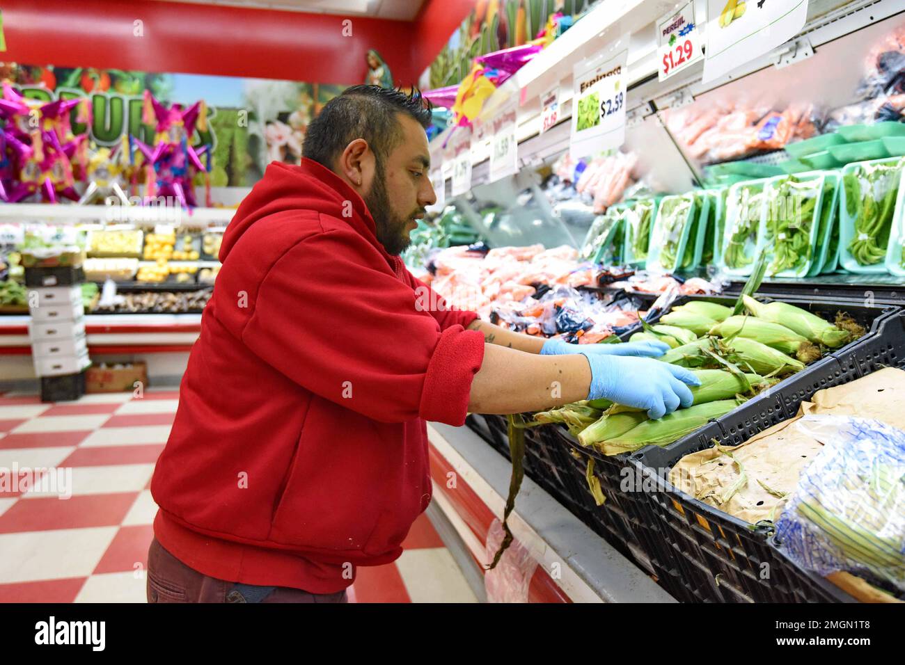 Adolfo Rodriguez, a 15 year employee at La Unica Supermarket wears ...