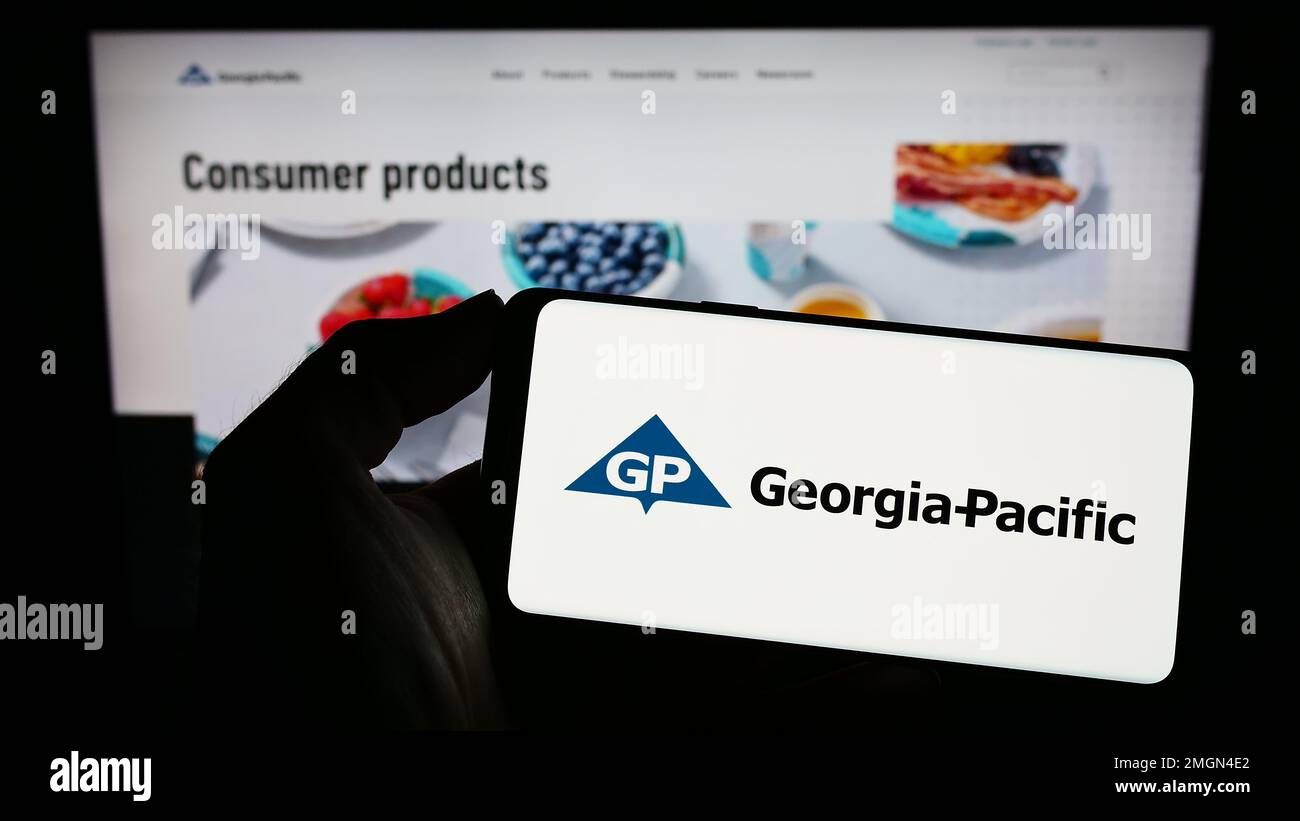 Person holding mobile phone with logo of American pulp and paper ...