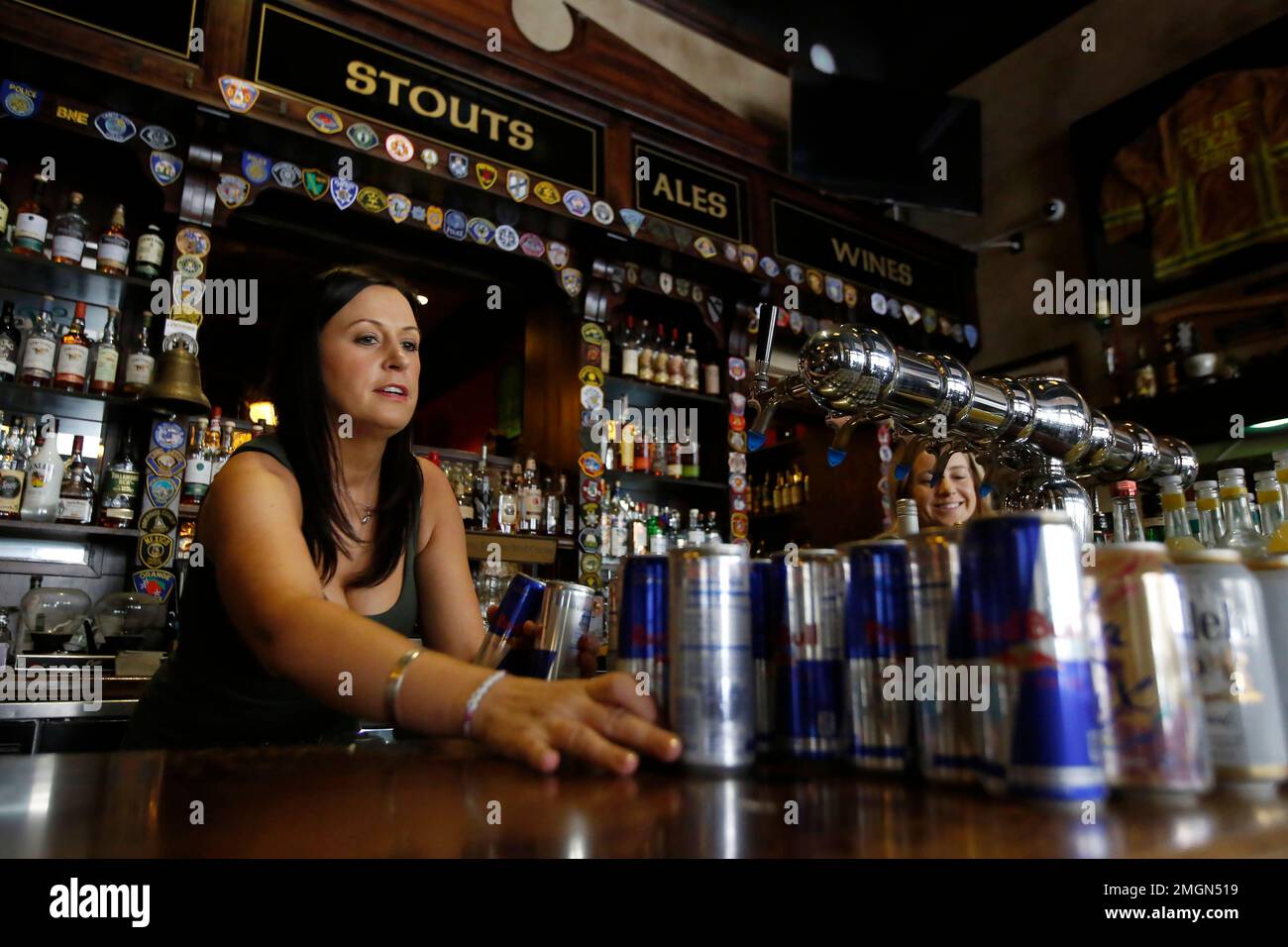 Bartender Courtney Schrag places beverage cans on the bar as she other ...