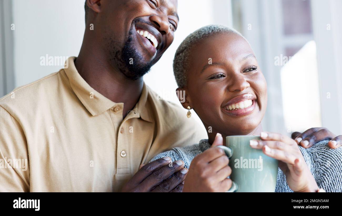 Relax, love and couple hug with coffee drink break at window to enjoy ...