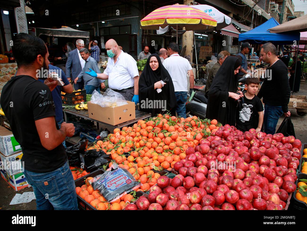 Iraqis buy groceries in downtown Baghdad, Iraq Monday, March 16, 2020 ...
