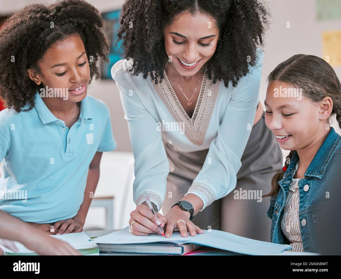 Helping students with homework, female teacher in classroom with ...