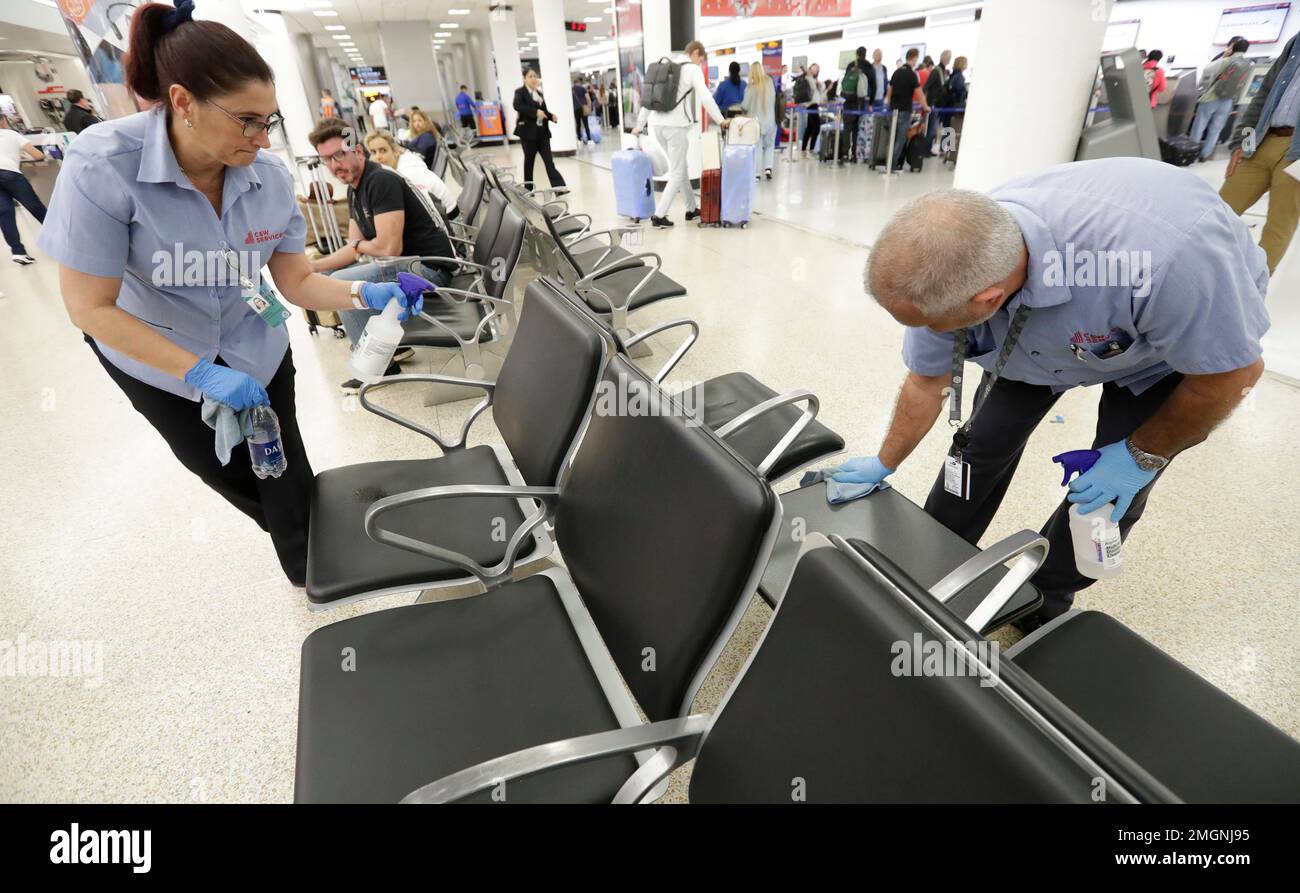 Workers clean disinfects seats near the check-in counters, Friday ...