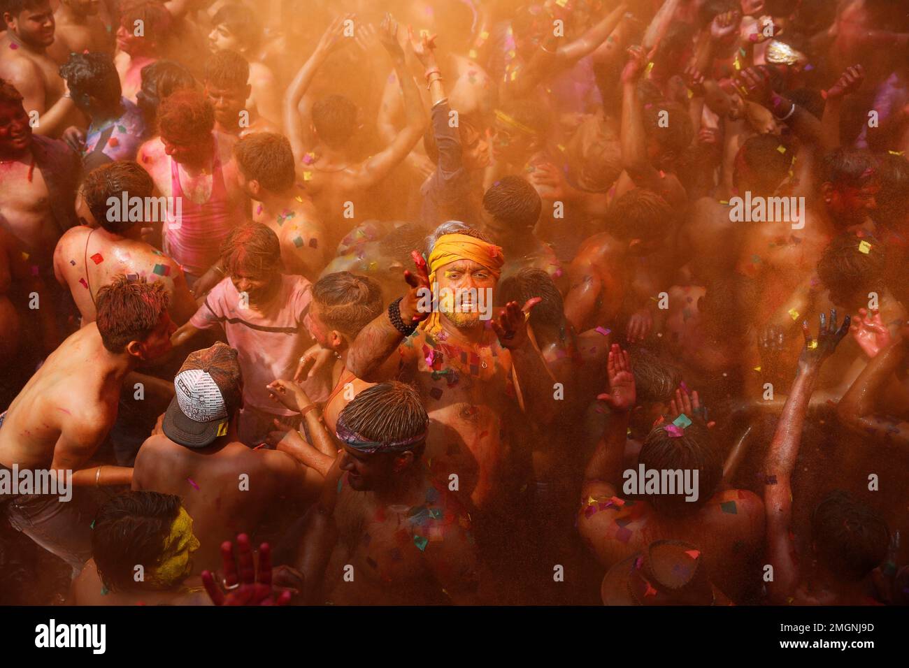 Revelers, faces smeared with colored powder, dance during celebrations ...