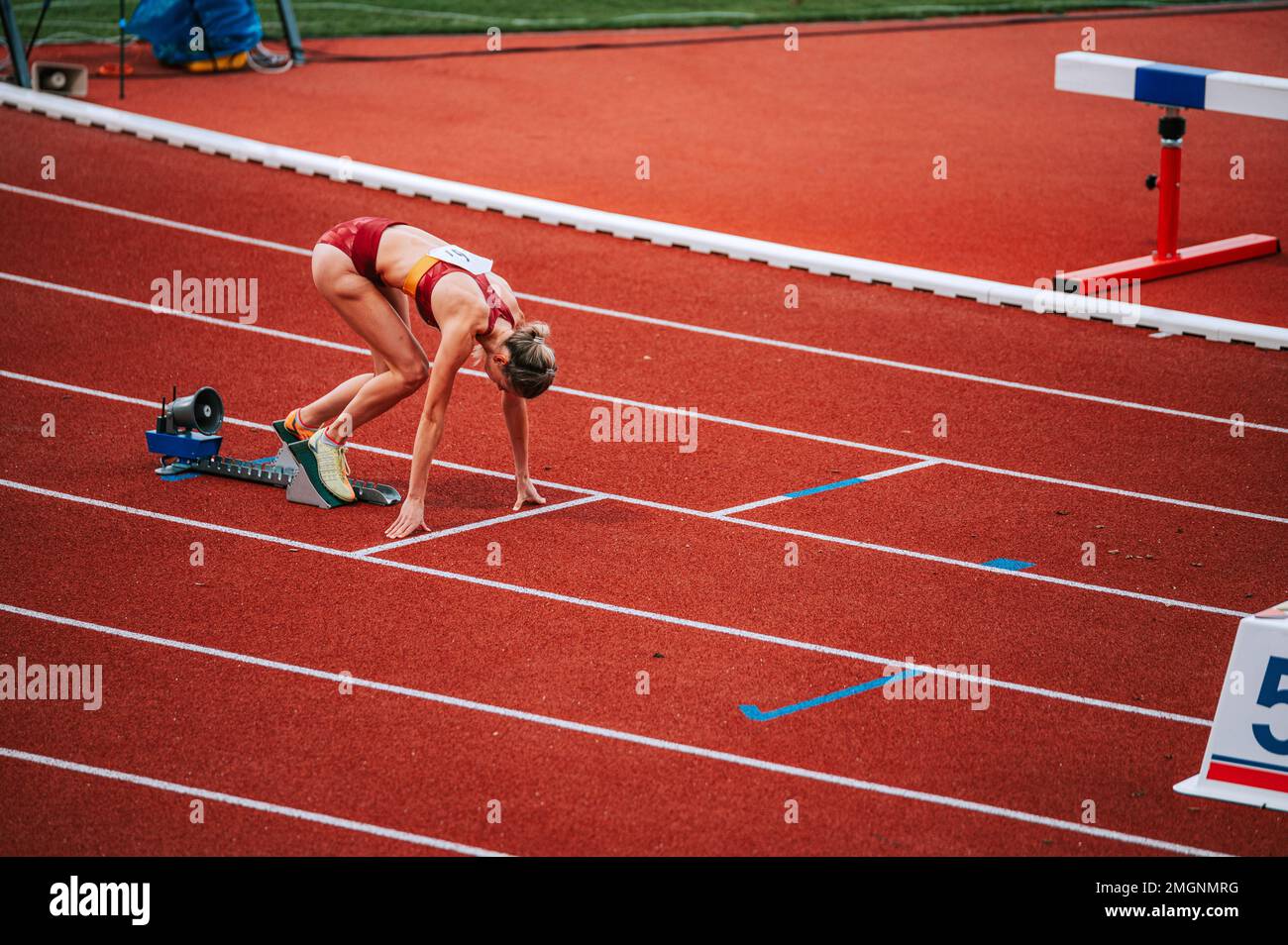 Female athlete at the starting line of a 400m race on track, captured ...