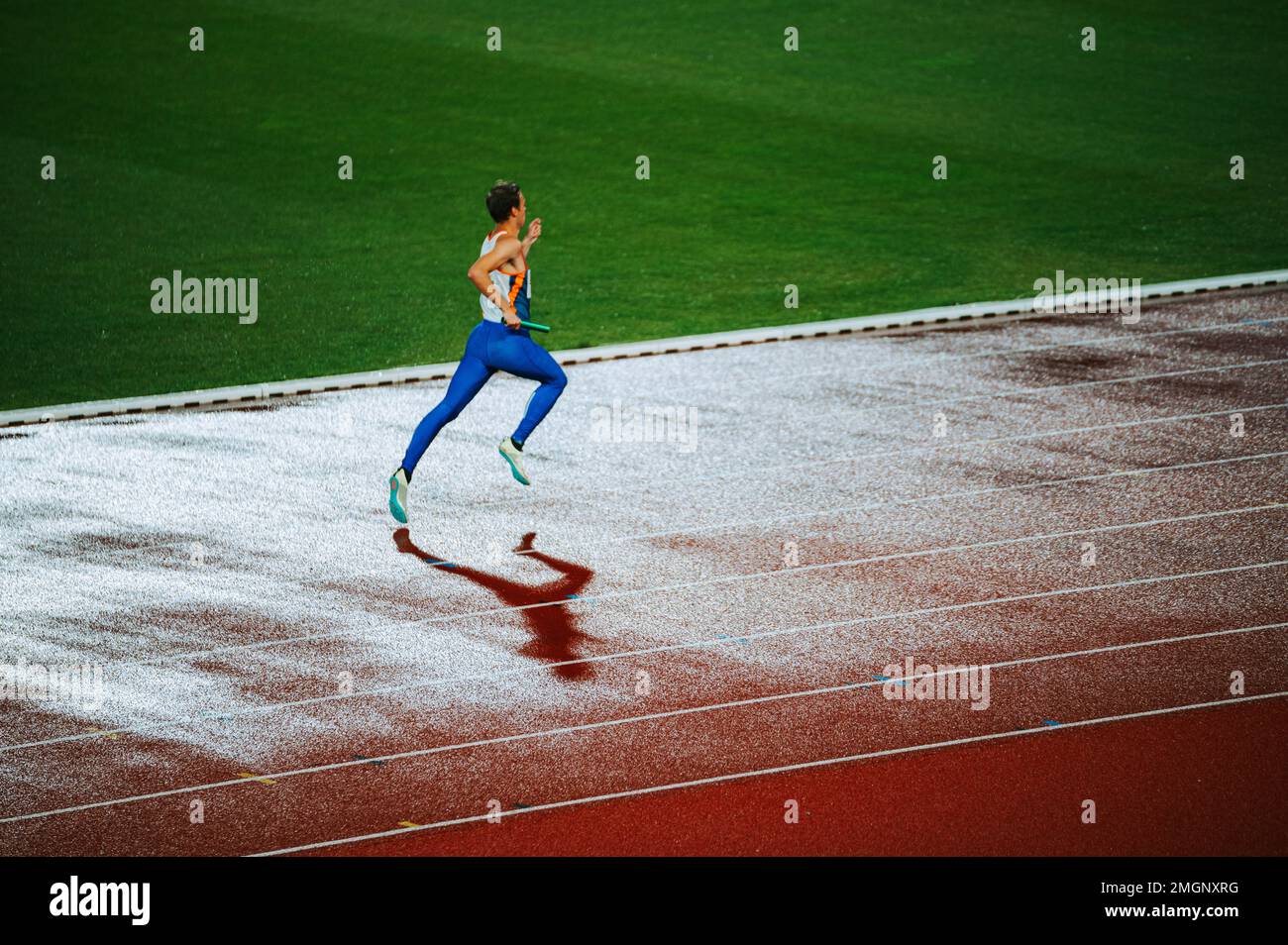 An intense sprinter pushing through the elements on a rainy athletics ...