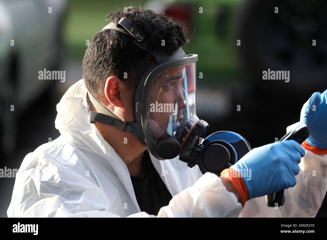 A worker from a Servpro disaster recovery team wears a protective suit ...