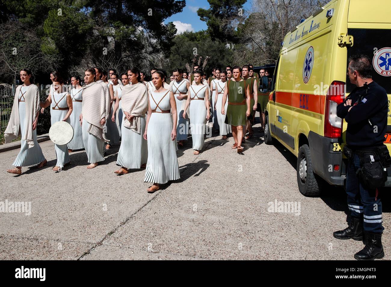 Performers dressed as priestesses walk by an ambulance as they arrive ...