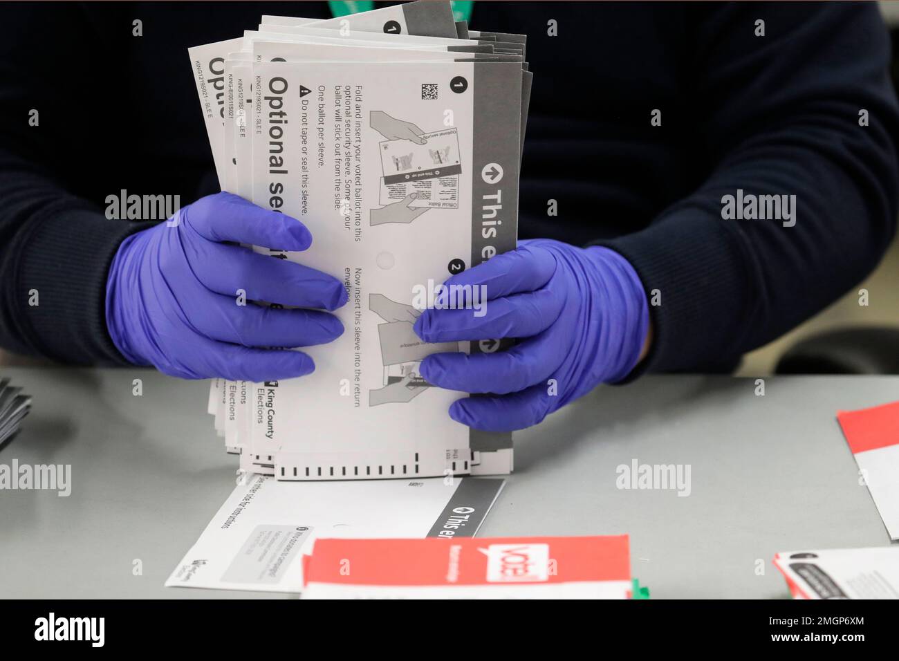 A worker wears gloves while handling ballots from the Washington state ...