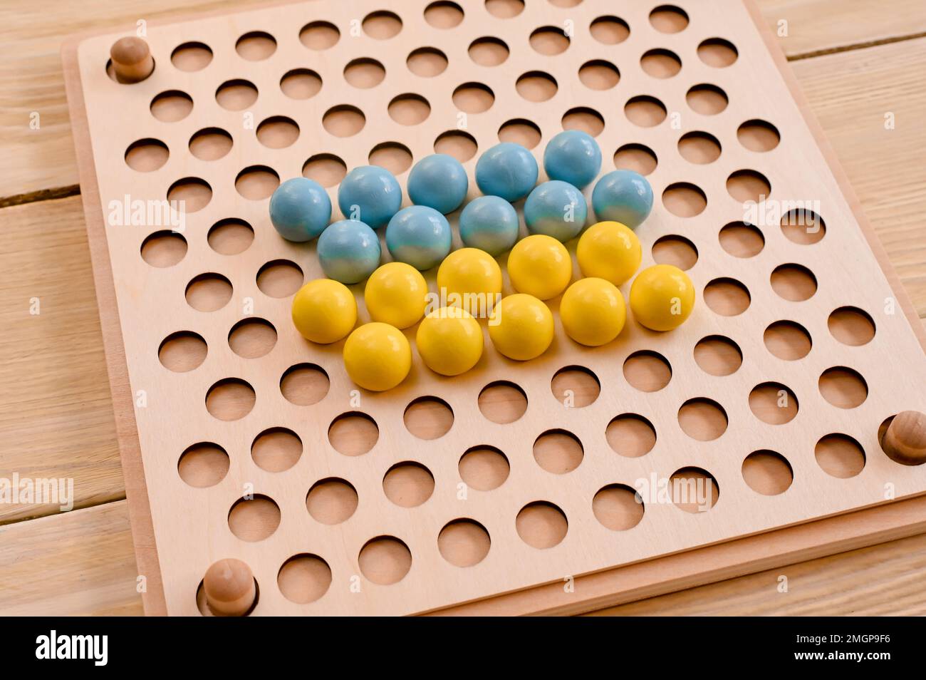 A board game made of wooden beads on a wooden background. Close-up. The ...