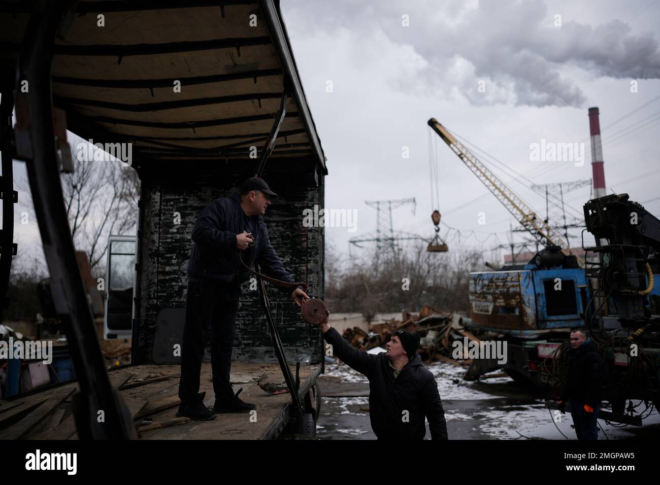 Men check a damaged truck at a site of a rocket attack in Kyiv, Ukraine ...