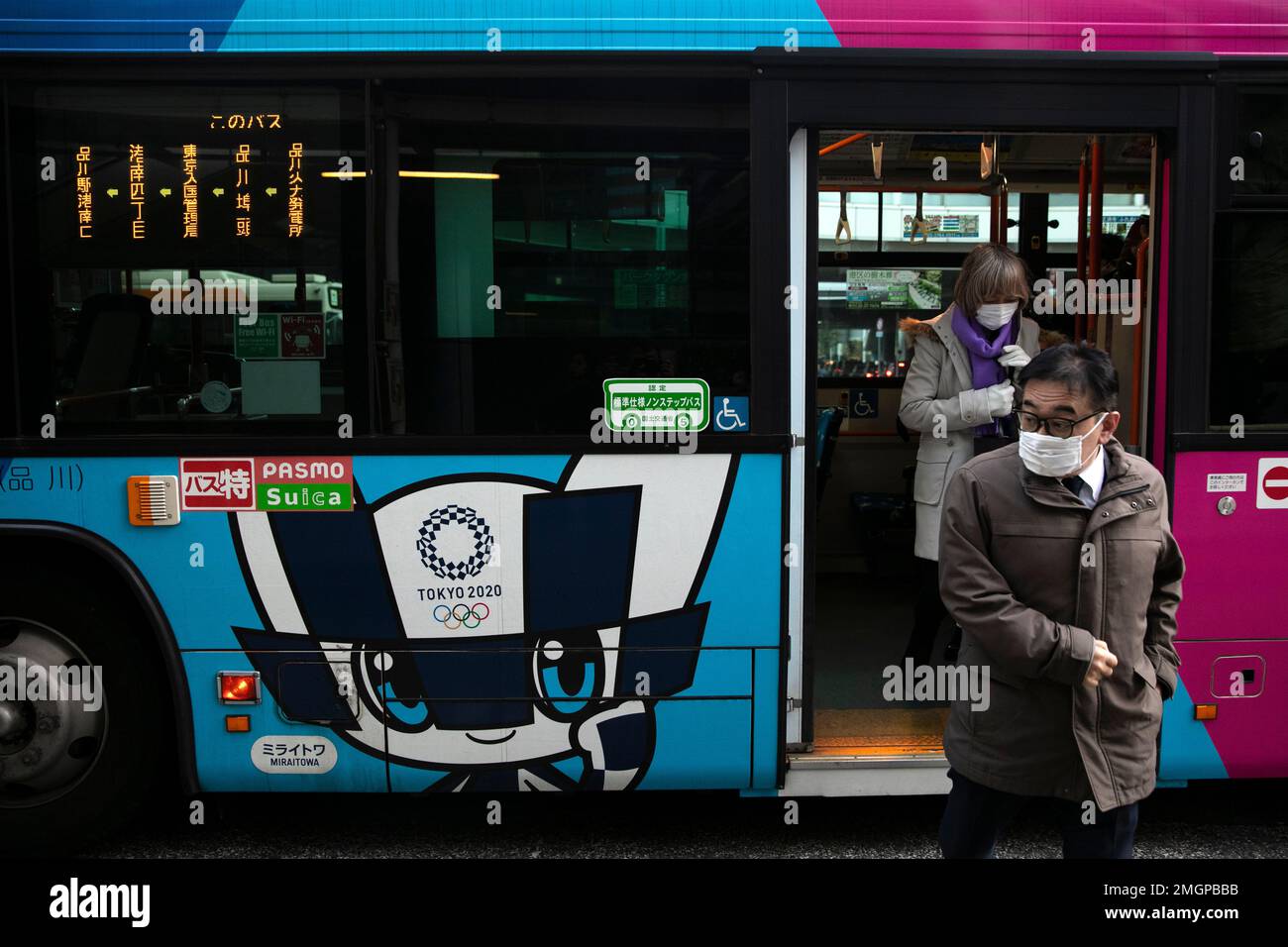 FILE - In this March 5, 2020, file photo, Passengers wearing masks get ...