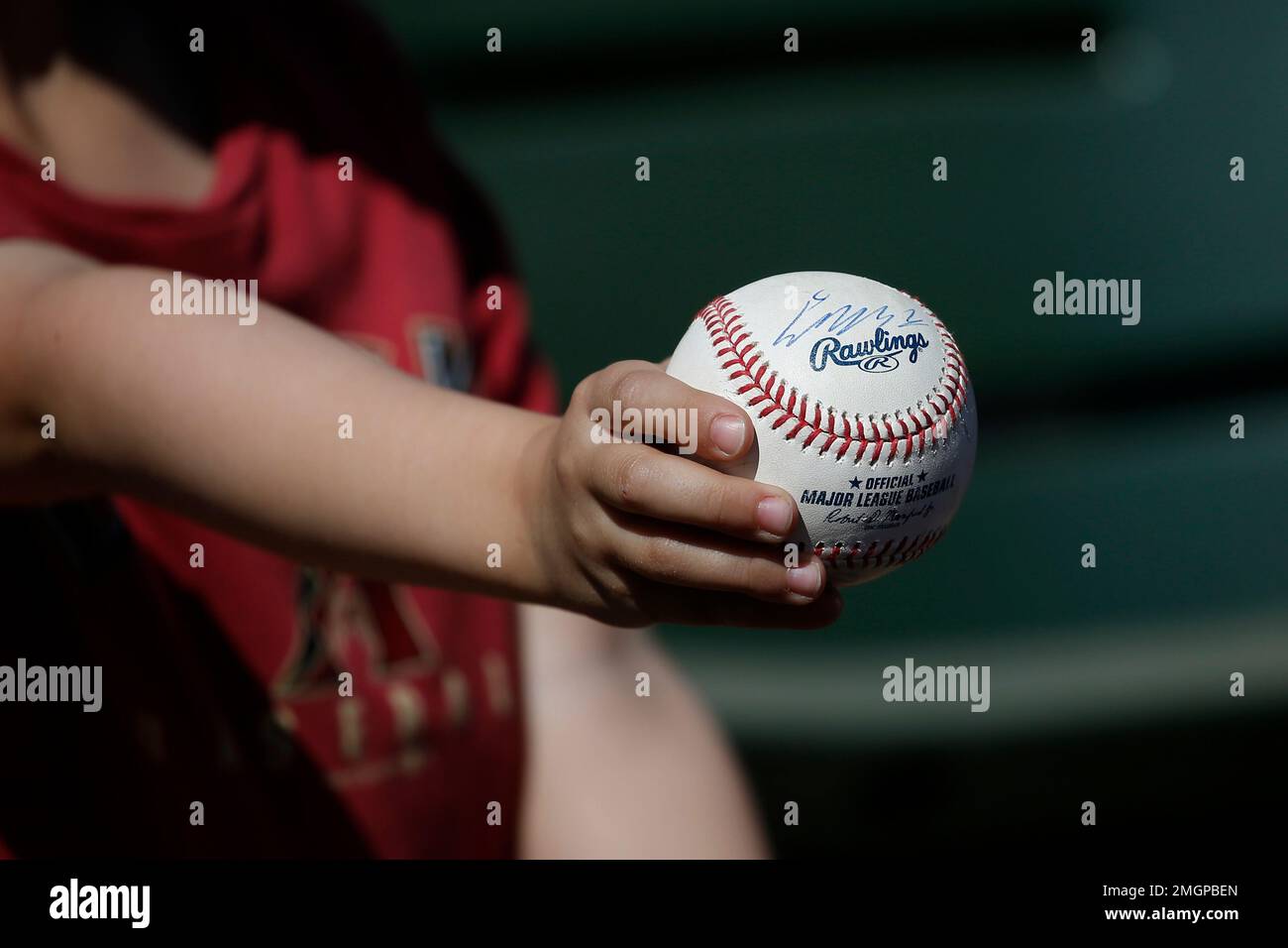 A fan holds out a baseball for an autograph prior to a spring training ...