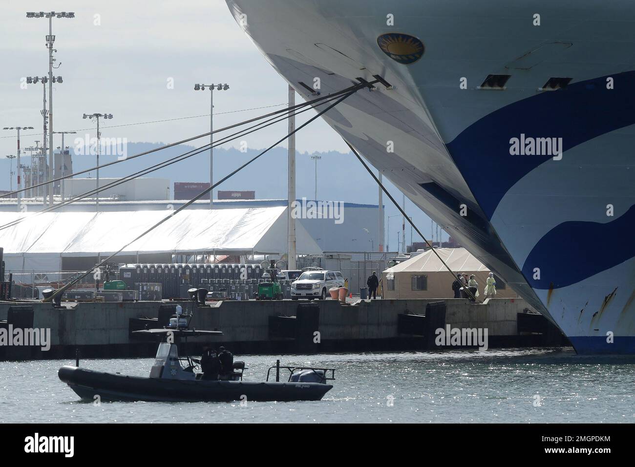 People walk below the Grand Princess, a cruise ship carrying multiple ...