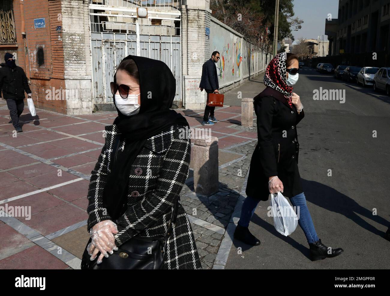 Pedestrians walk as some of them wear masks in downtown Tehran, Iran ...