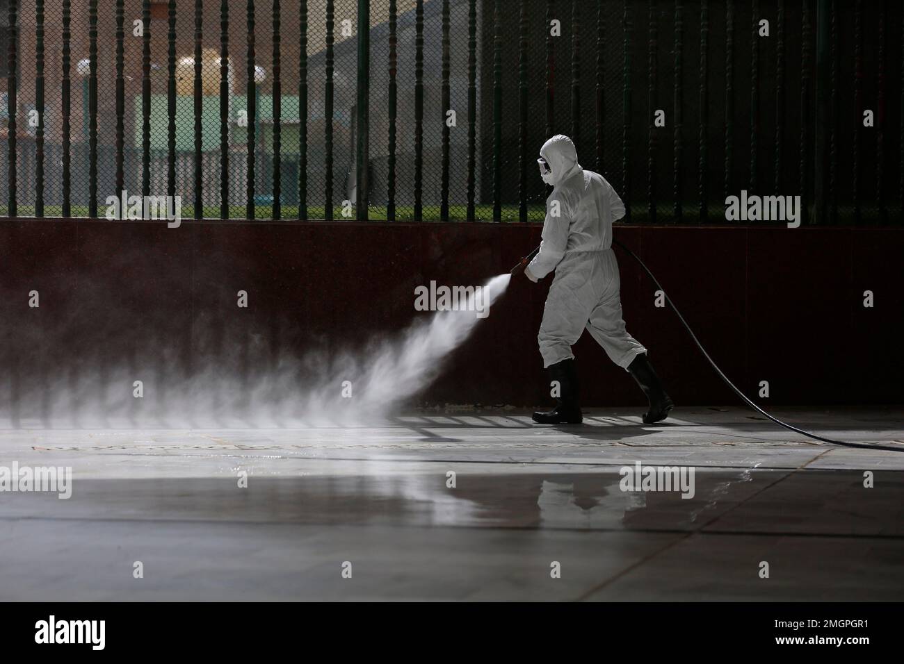 Iraqi health officials spray disinfectant as a precaution against the ...