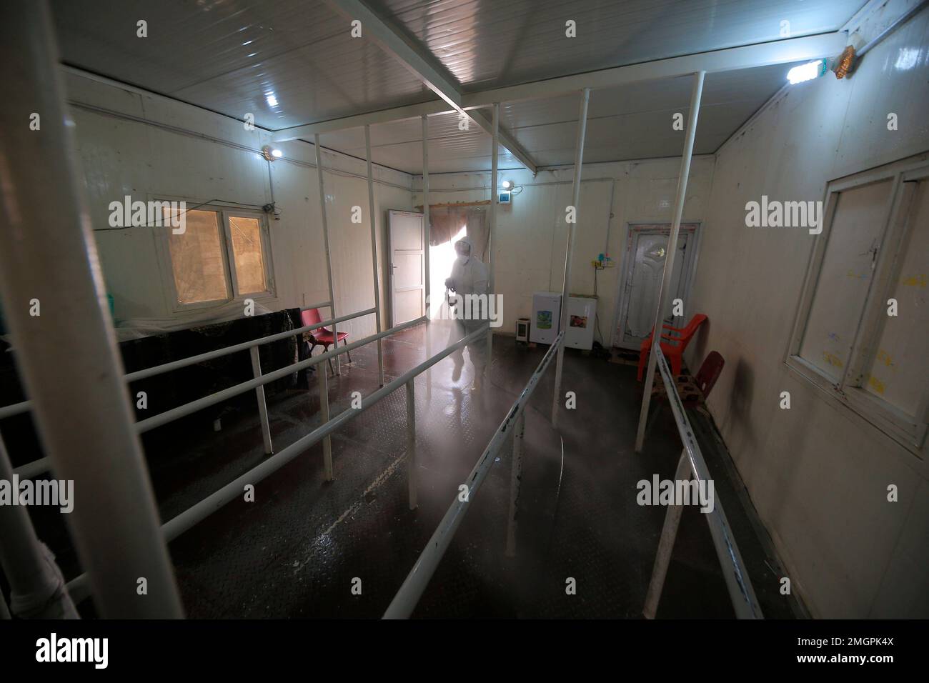 Iraqi health officials spray disinfectant as a precaution against the ...