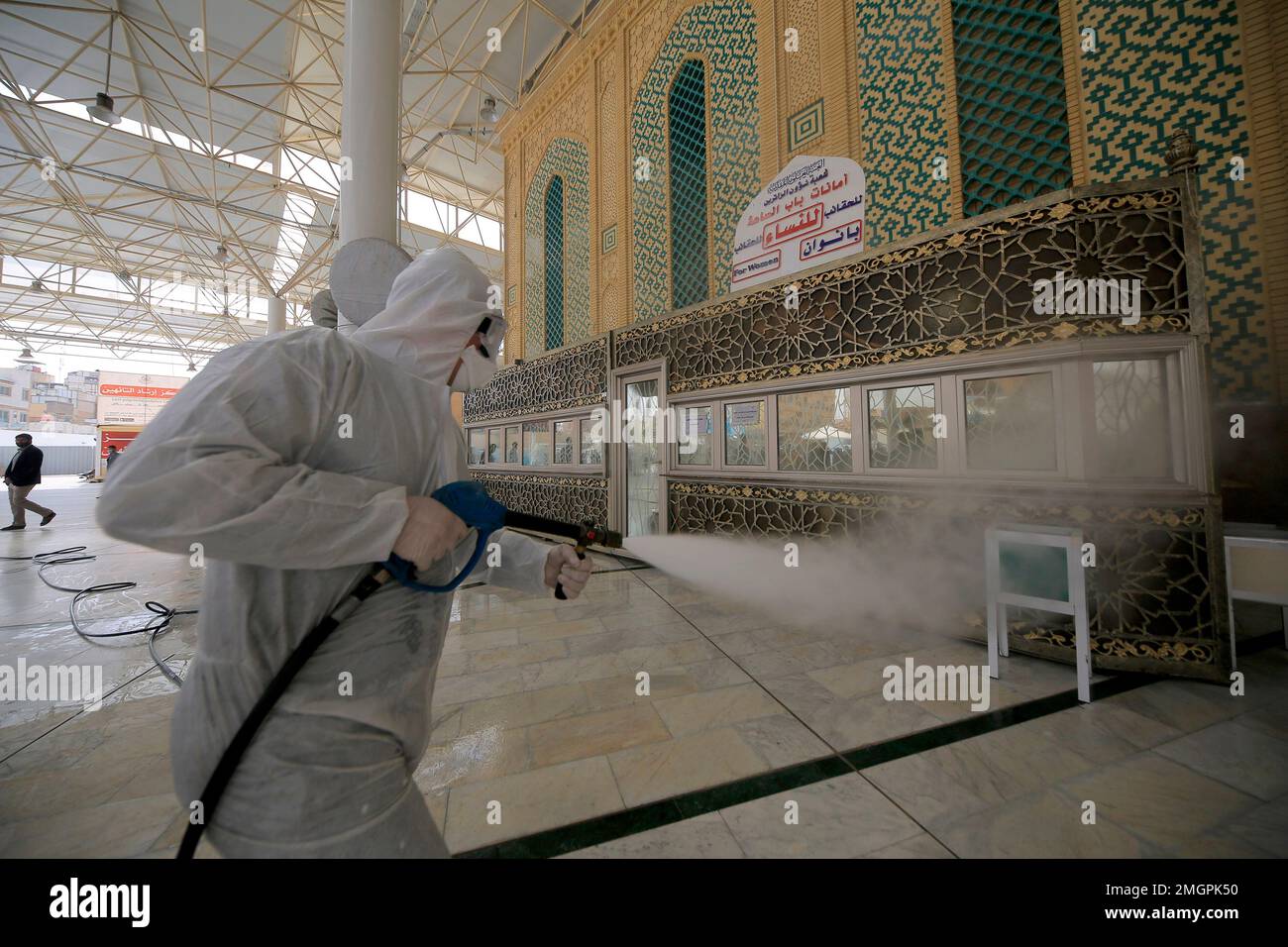 Iraqi workers spray disinfectant as a precaution against the ...