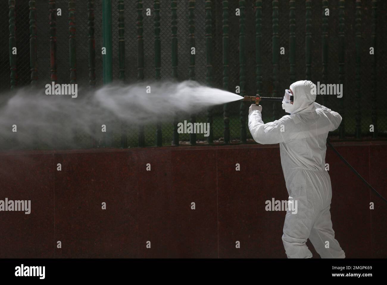 Iraqi workers spray disinfectant as a precaution against the ...