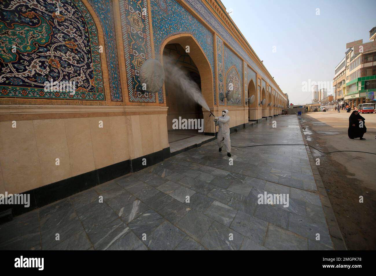 Iraqi workers spray disinfectant as a precaution against the ...