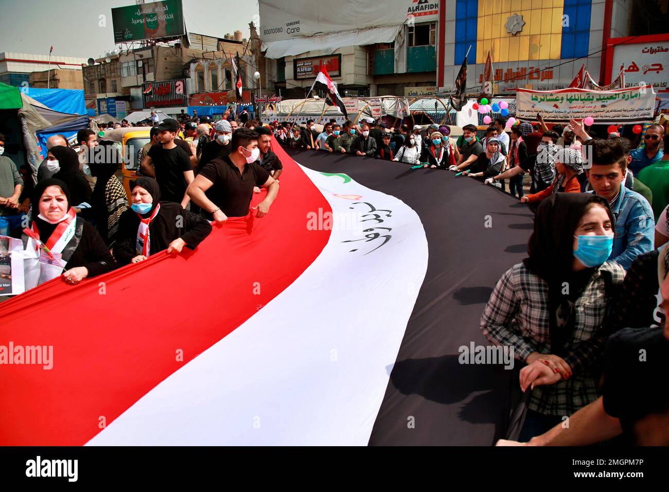 Anti-government protesters hold Iraqi flags during a rally demanding ...