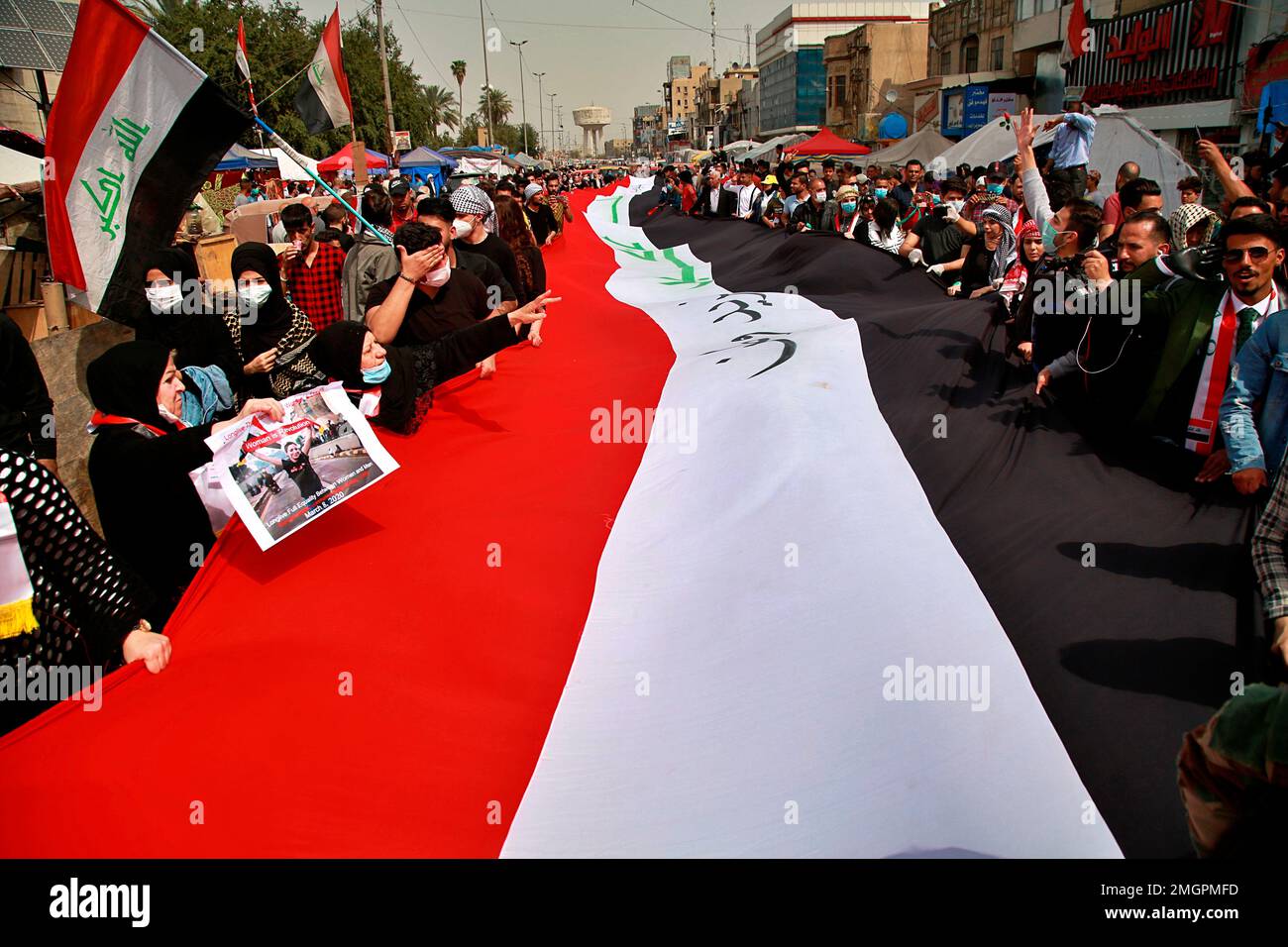 Anti-government protesters hold Iraqi flags during a rally demanding ...