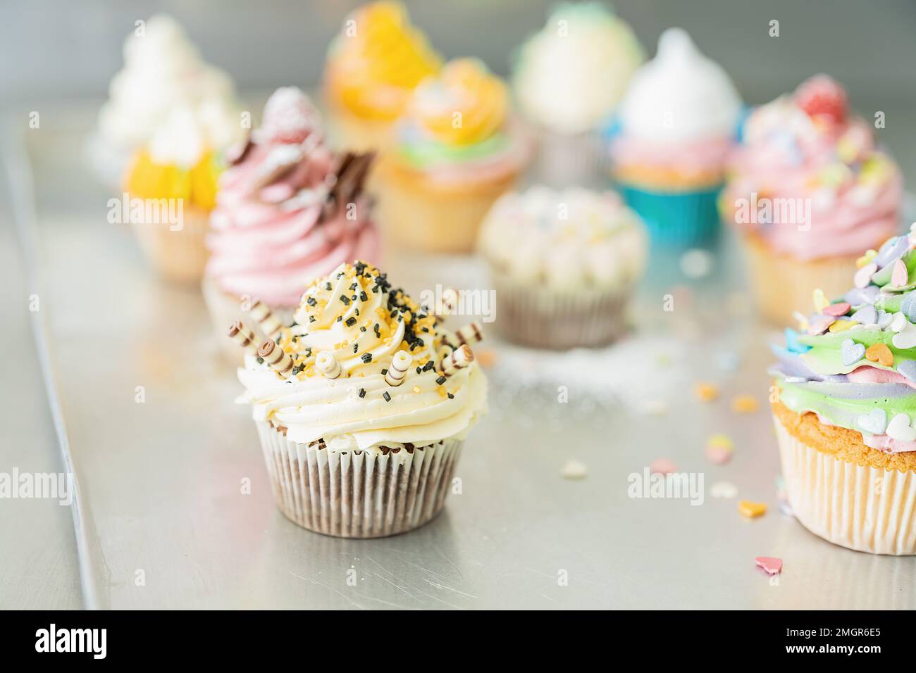 Tasty cupcakes on a metal sheet table in confectionery Stock Photo - Alamy