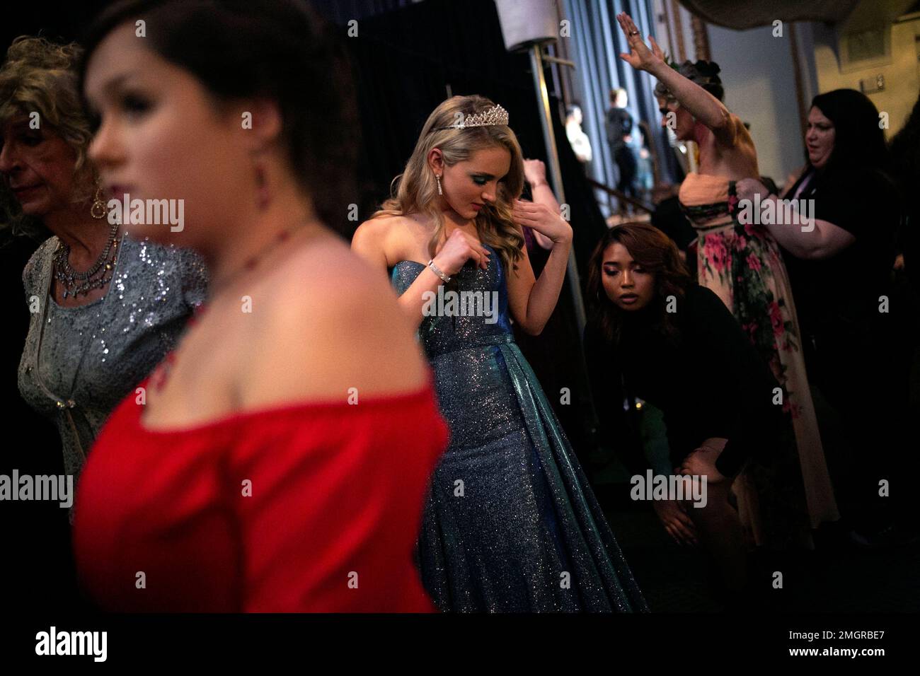 Emily Tressa, 18, center, looks down while her best friend AJ adjusts ...