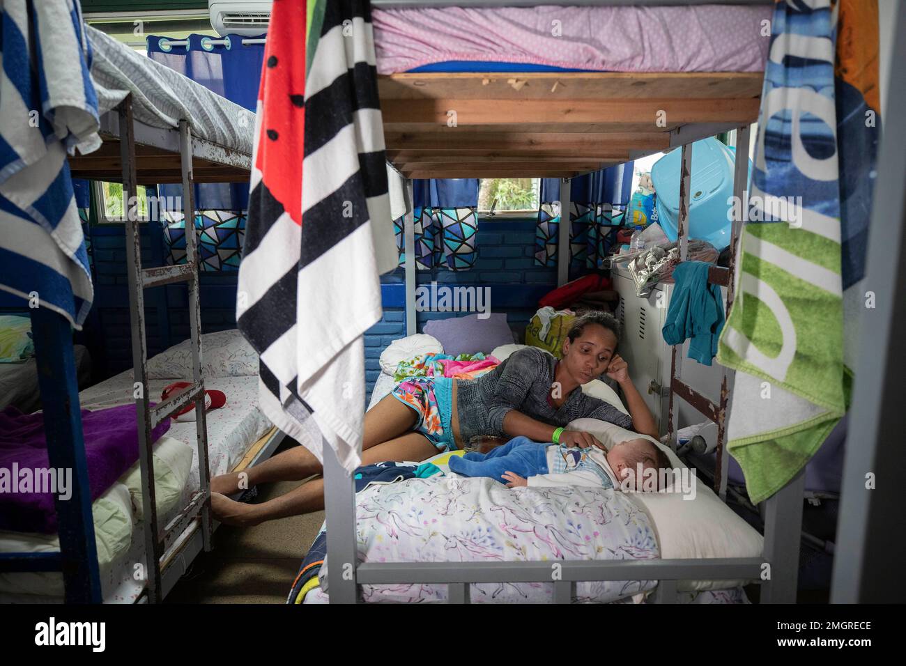 Veronica dos Santos and her son Antony rest at a school used as a ...