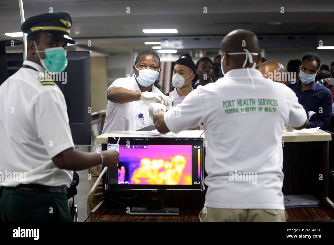 A Nigerian port health official, right, uses a thermometer to screen ...