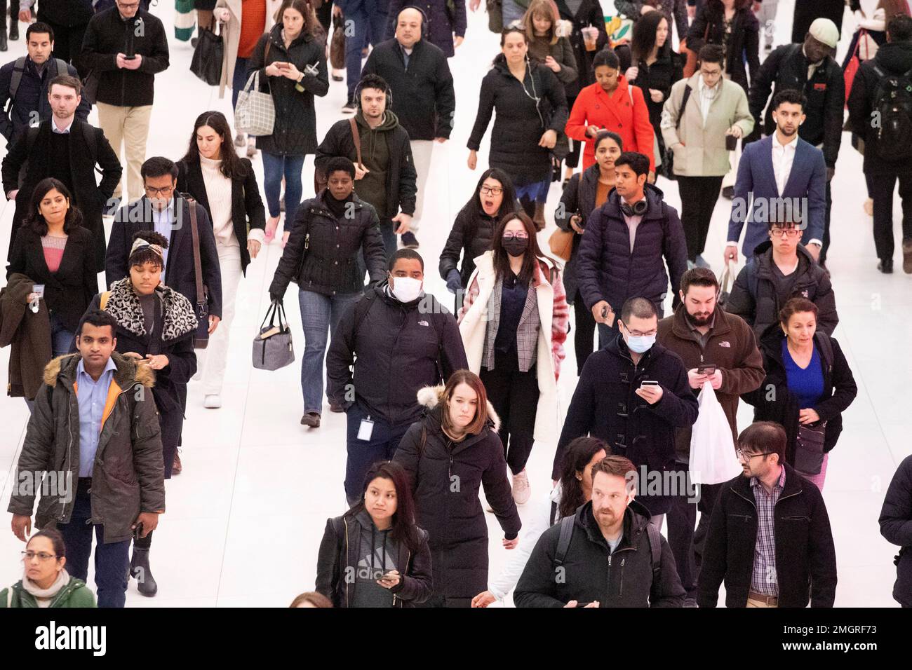 Three commuters, center, wear masks as they walk through the World ...