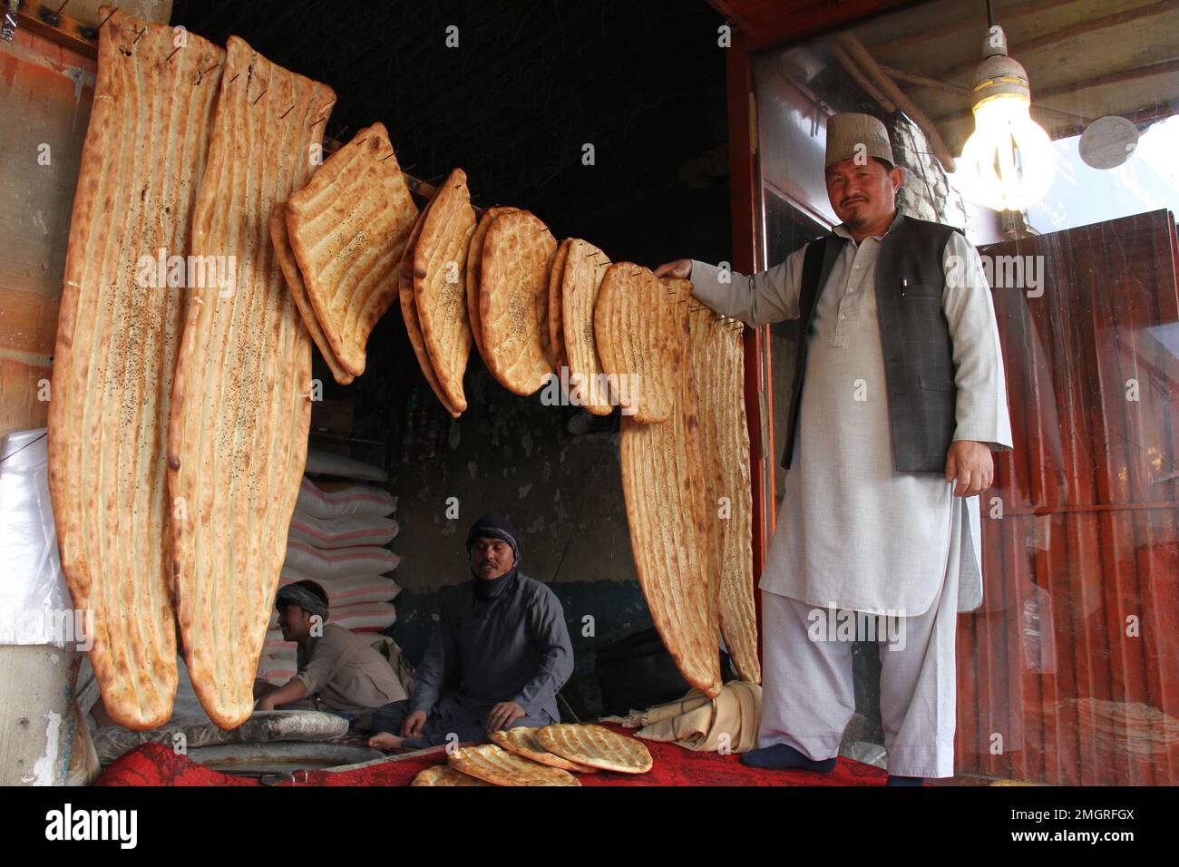 Balkh, Afghanistan. 24th Jan, 2023. A man poses for photos with naan ...