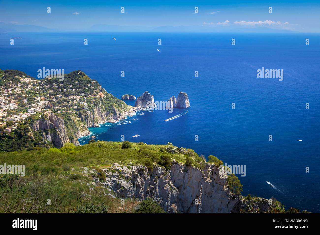 Above Capri city cliffs and Faraglioni with boats and yacht, amalfi ...