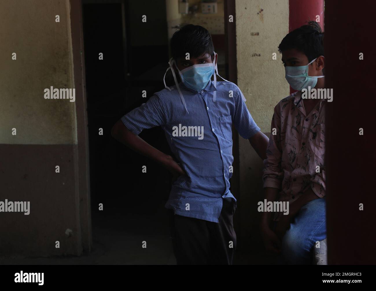Indian students wear masks and stand in the corridor of their hostel in ...