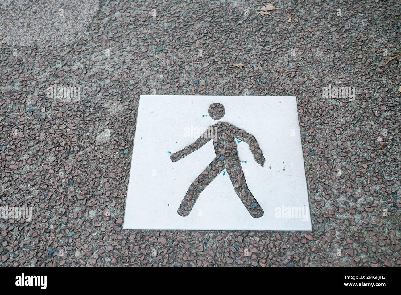 White pedestrian walking icon sign paint on sidewalk Stock Photo - Alamy