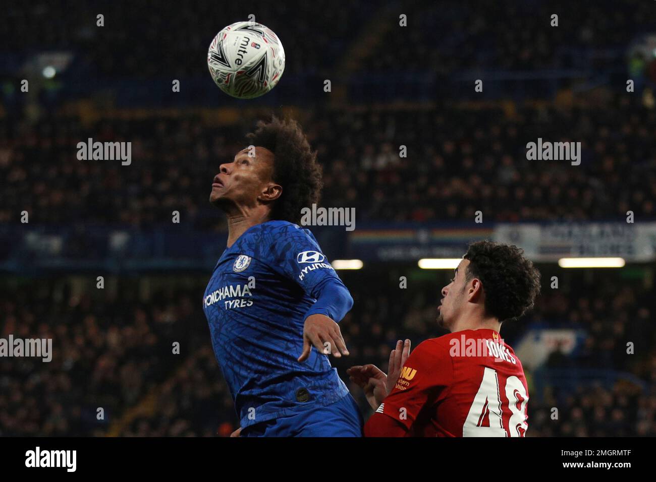 Chelsea's Willian, left, heads the ball past Liverpool's Curtis Jones ...