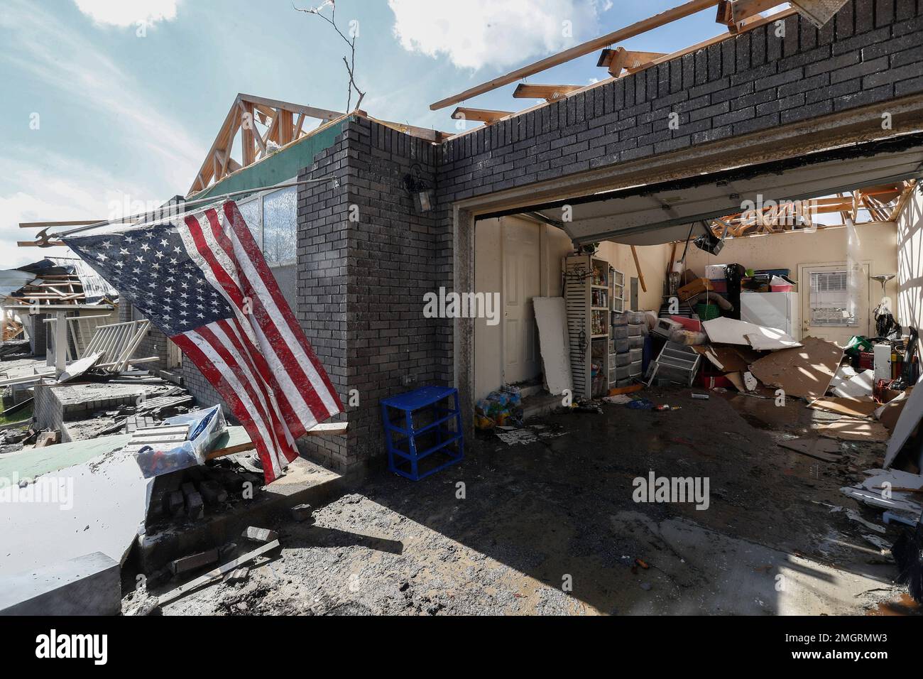 A US flag hangs outside a damaged home Tuesday, March 3, 2020, in ...