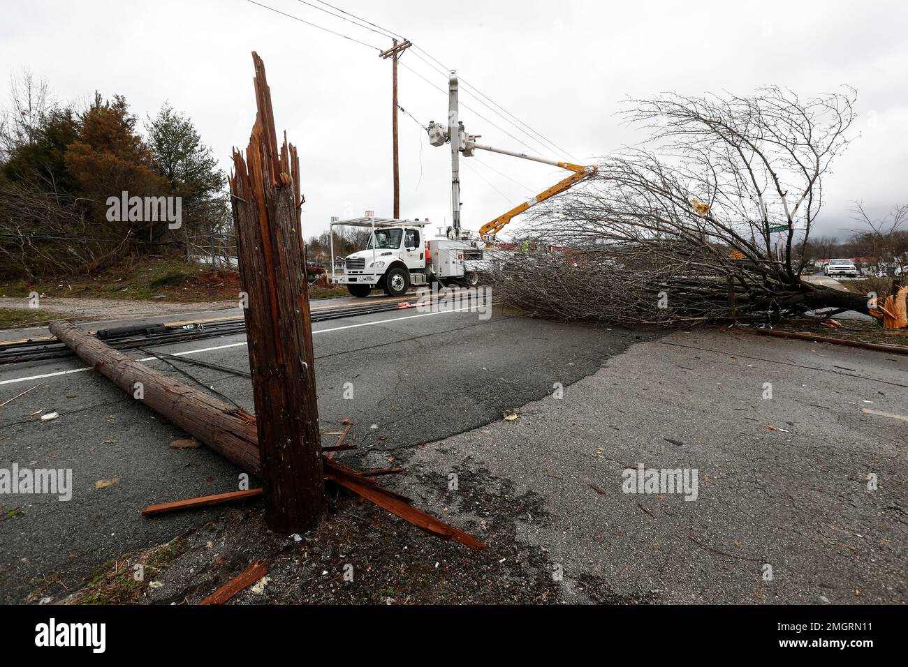 Workers repair power lines Tuesday, March 3, 2020, after a tornado ...