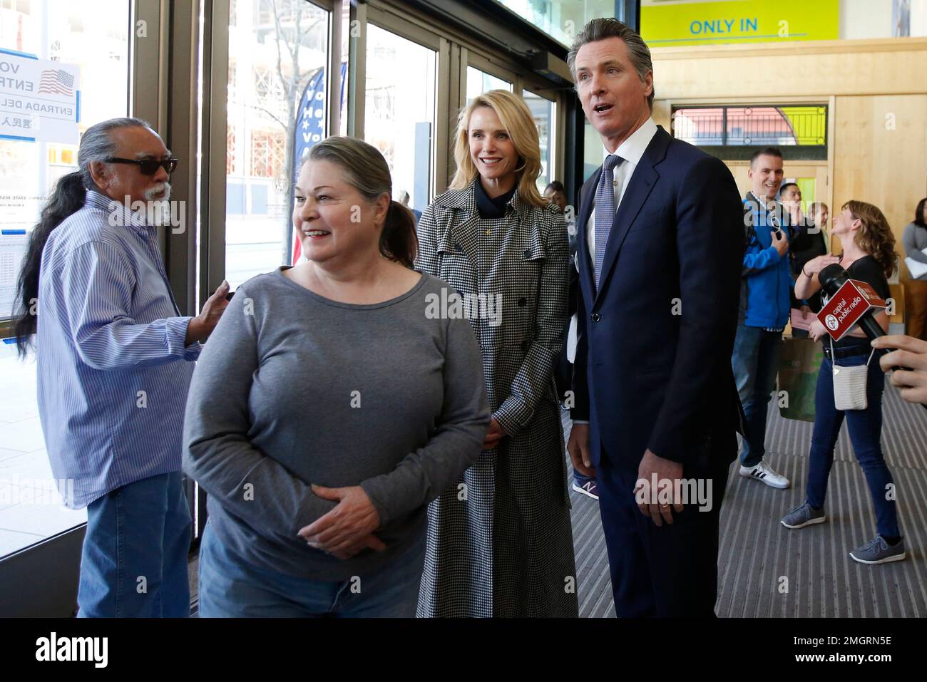 California Gov. Gavin Newsom, right, waits in line to vote with his ...