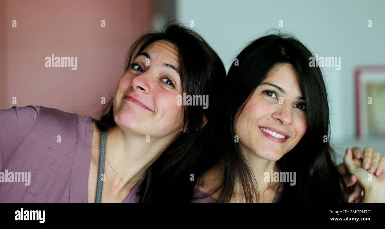 Two pretty brunette twins smiling hi-res stock photography and images ...