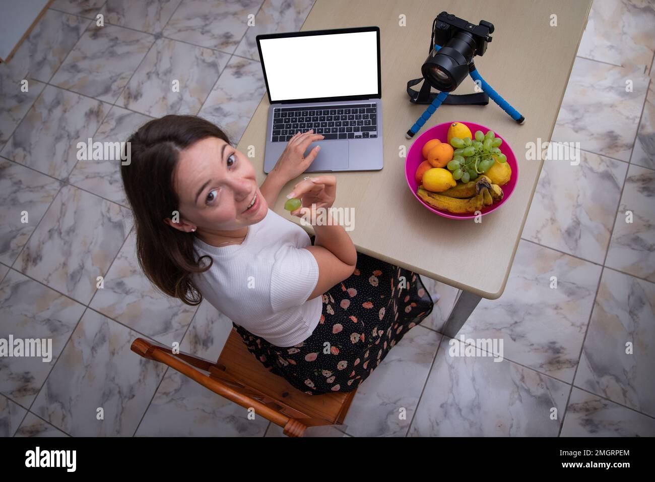 A female online content creator films herself talking about nutrition, mockup laptop screen ...