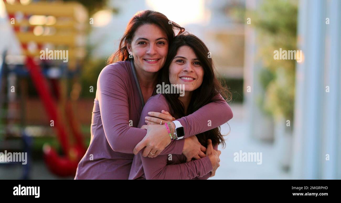 Two adult happy sisters posing together outside twin siblings with same ...