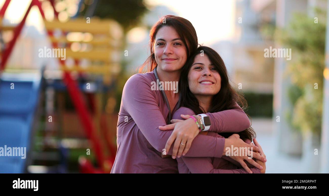 Two adult happy sisters posing together outside twin siblings with same ...