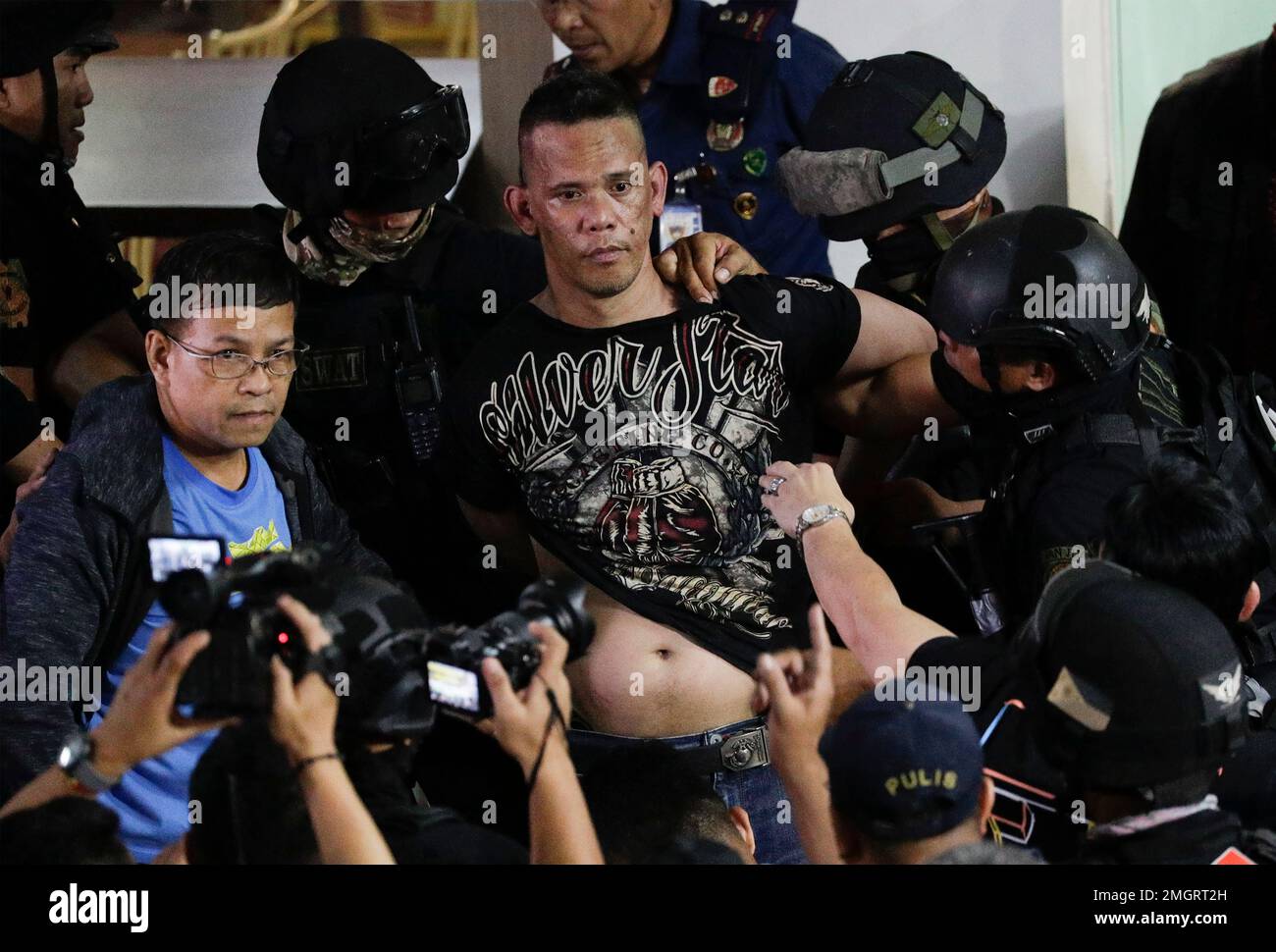 Police take hostage taker Alchie Paray into custody as he speaks to media shortly after ...