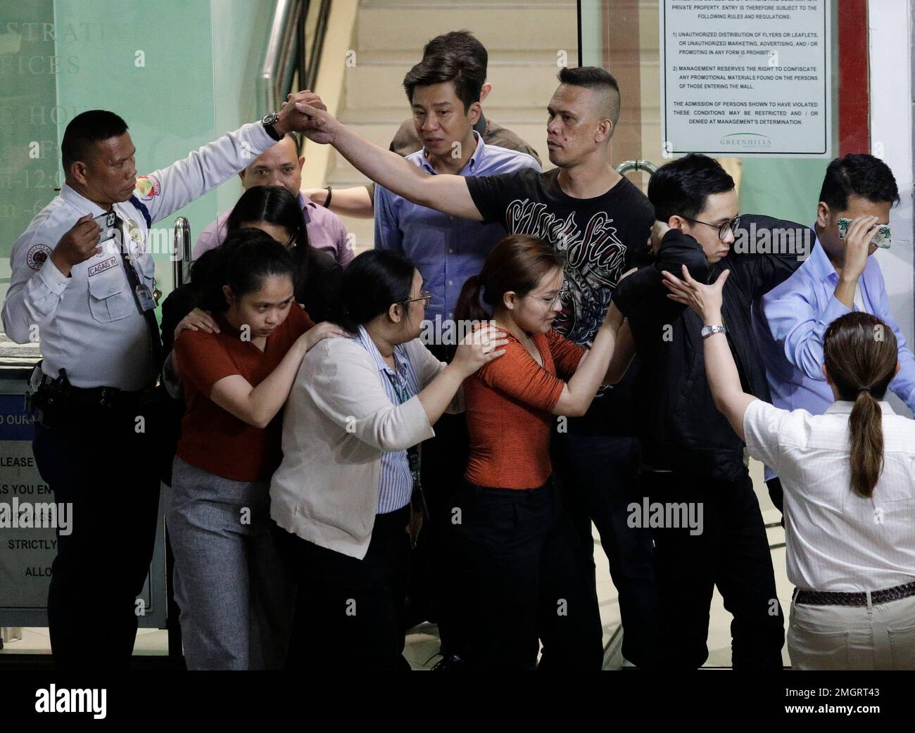 Hostage taker Alchie Paray, right, shakes hands with a security guard in uniform as he after ...